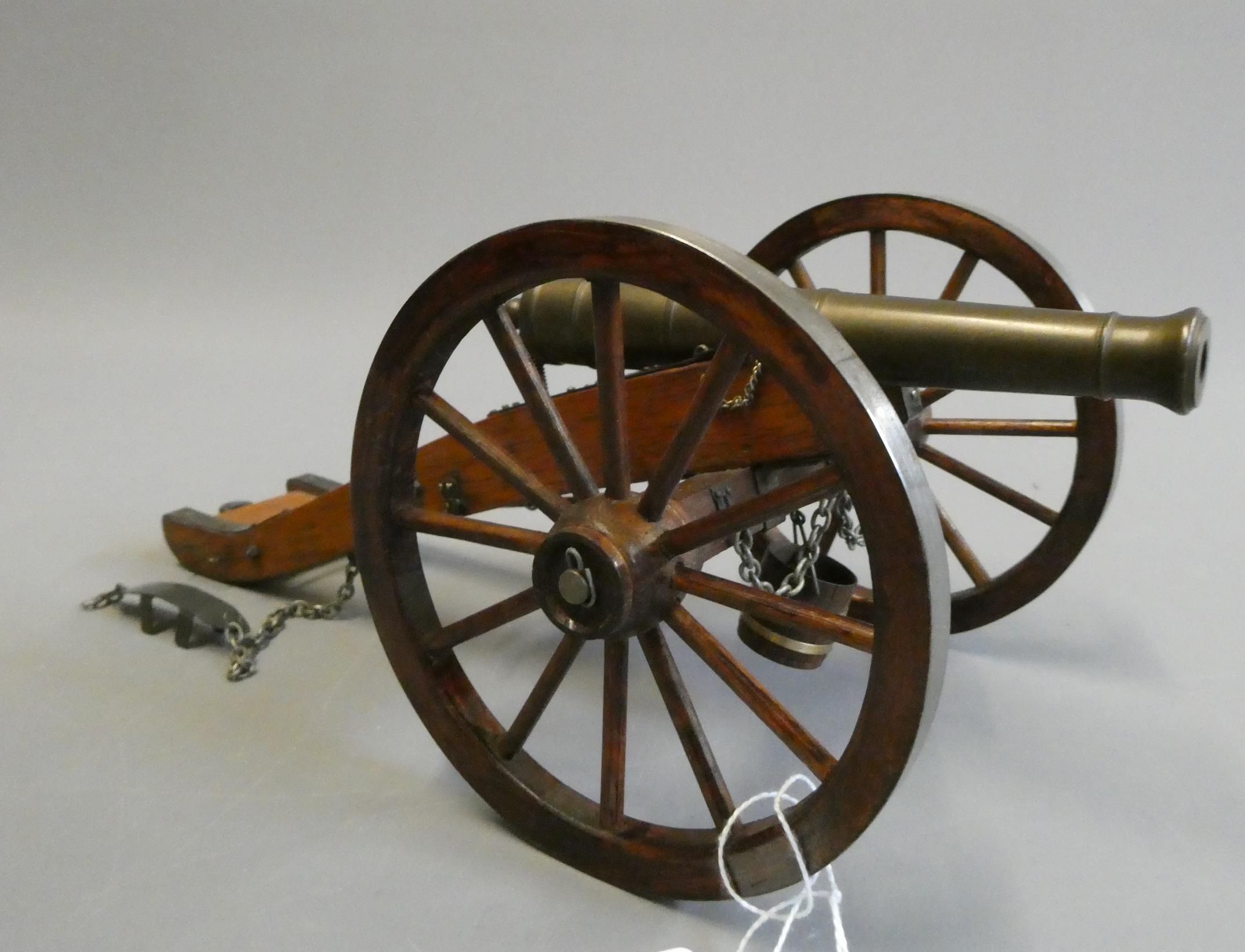A well-made wooden and brass field gun, mounted on trolley with spoked ...