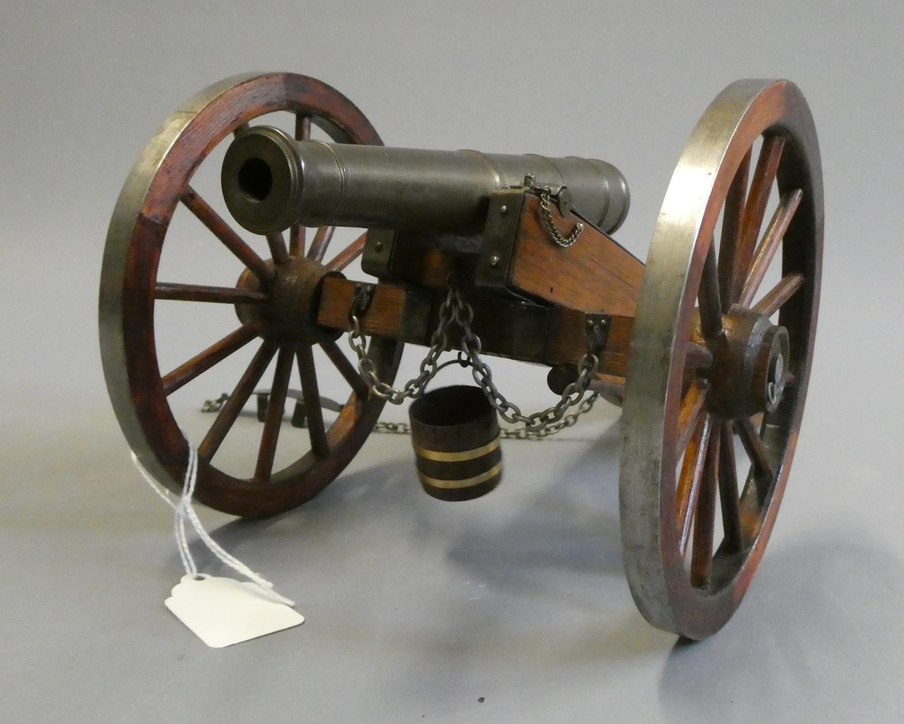 A well-made wooden and brass field gun, mounted on trolley with spoked ...