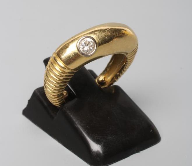 An unusual diamond ring, the plain wide panel offset with a collet set ...