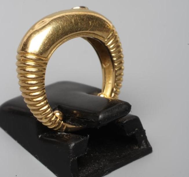 An unusual diamond ring, the plain wide panel offset with a collet set ...