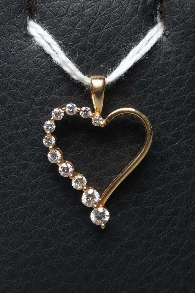 A diamond heart pendant, one side claw set with eleven graduated ...