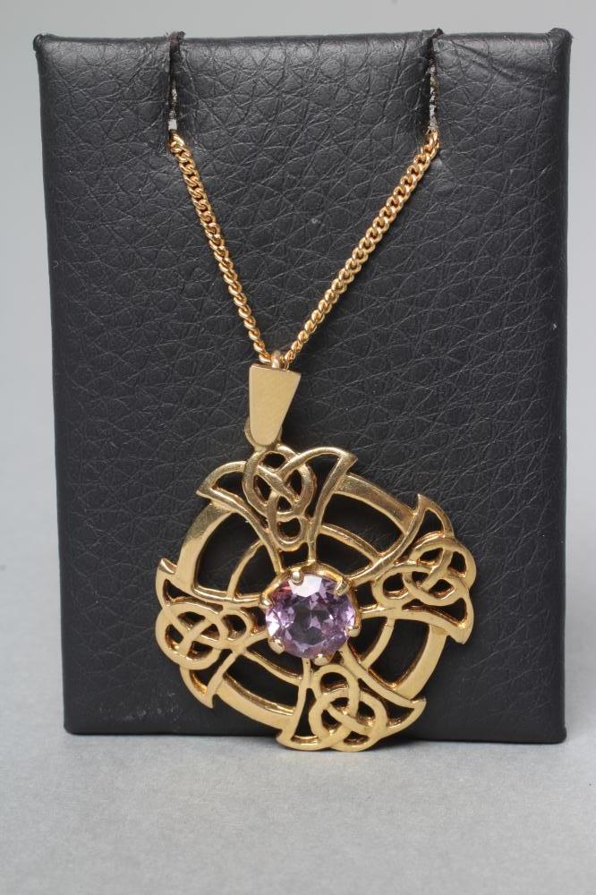 A 9ct gold celtic style pendant centred by a claw set amethyst on 9ct ...
