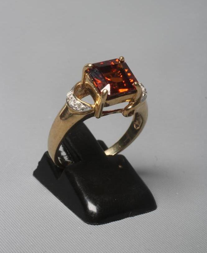 A garnet dress ring, the square facet cut stone claw set to diamond ...