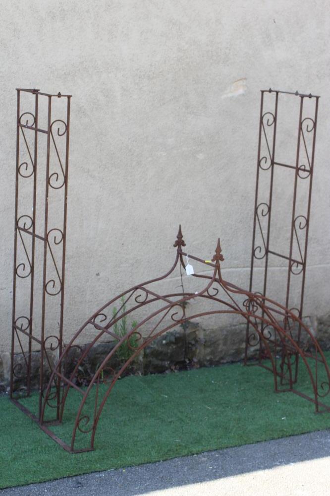 A wrought iron rose arch, modern, the openwork rounded arch with spear ...
