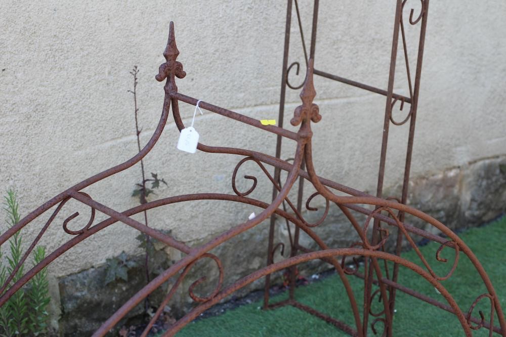 A wrought iron rose arch, modern, the openwork rounded arch with spear ...