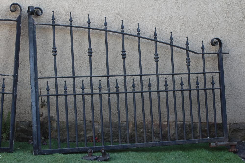 A pair of ironwork entrance gates, late 20th century, of arched barred ...