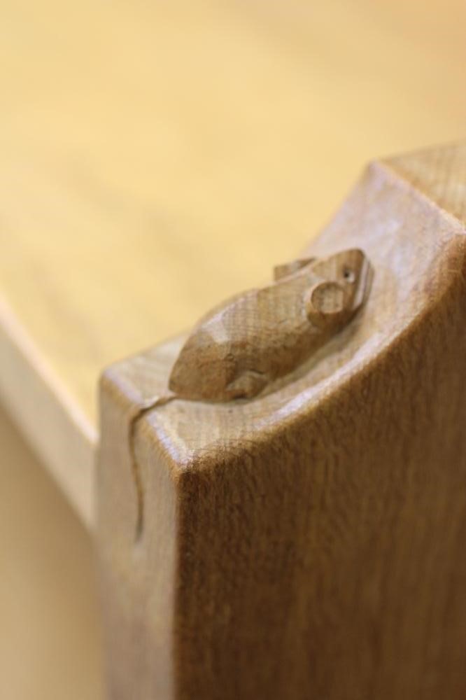 A robert thompson adzed oak open bookcase with galleried top and four ...