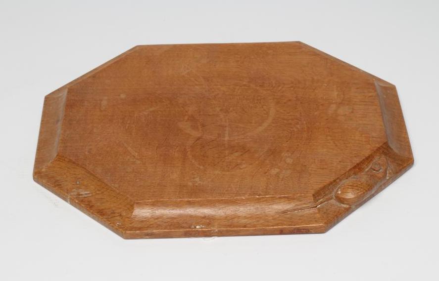 A robert thompson adzed oak bread board of canted oblong form, the ...