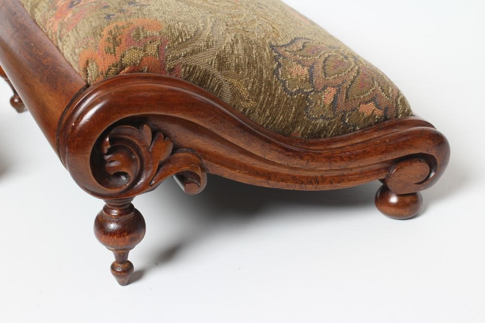 A pair of victorian walnut show frame footstools of sloping oblong form ...