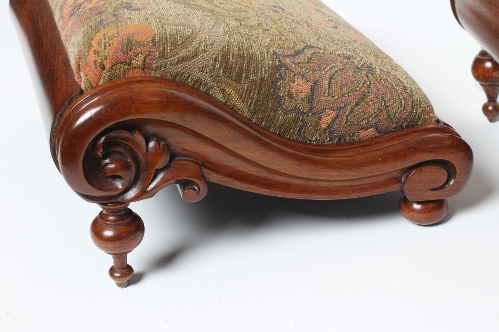 A pair of victorian walnut show frame footstools of sloping oblong form ...