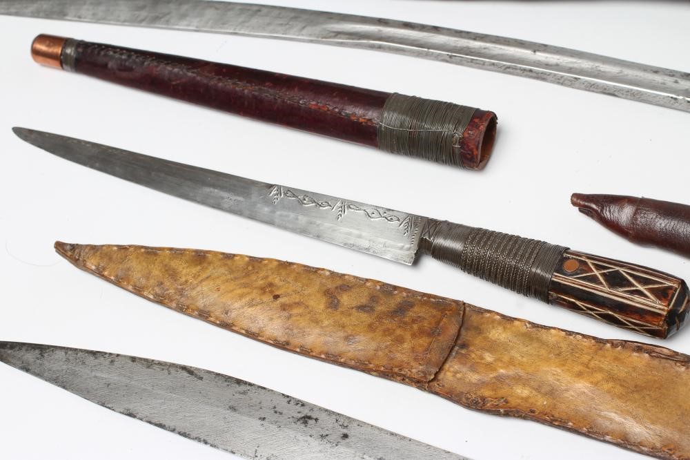 Four african edged weapons comprising two bou saa'da daggers with ...