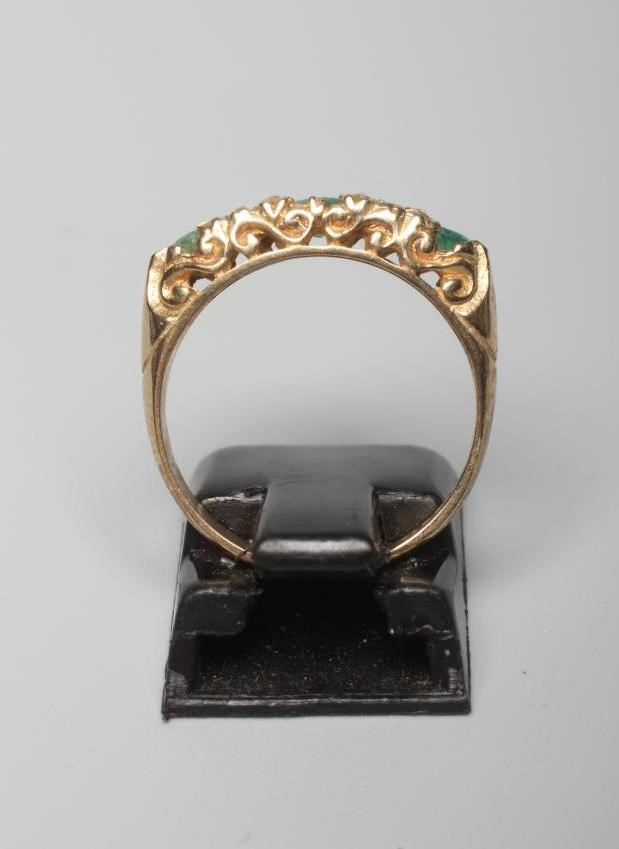 An emerald and diamond half hoop ring, the three circular facet cut ...