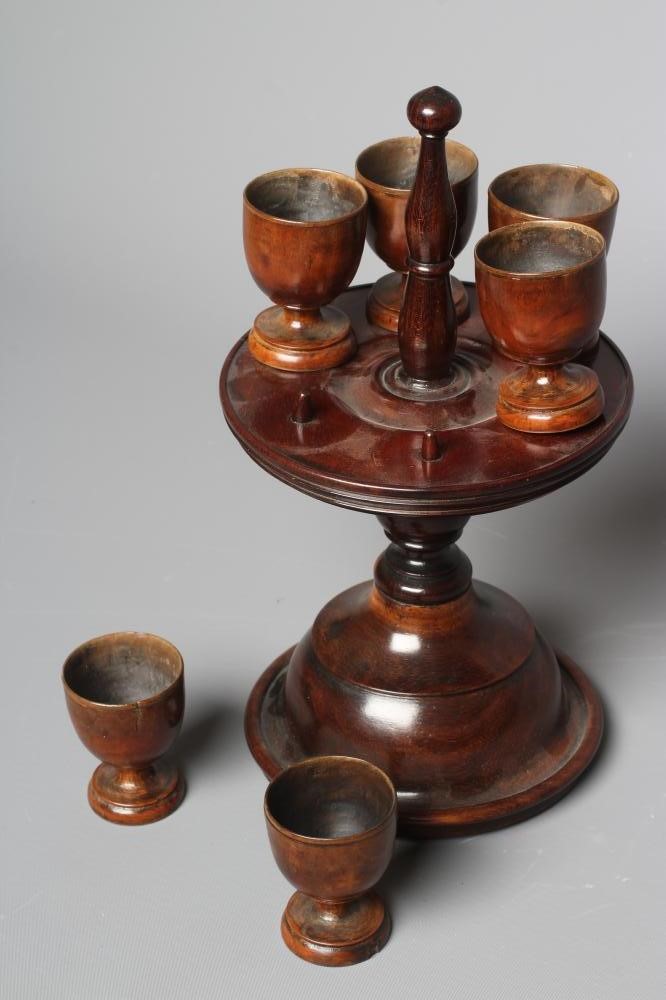 A 19th century turned mahogany egg cruet, with six cups on an upper ...