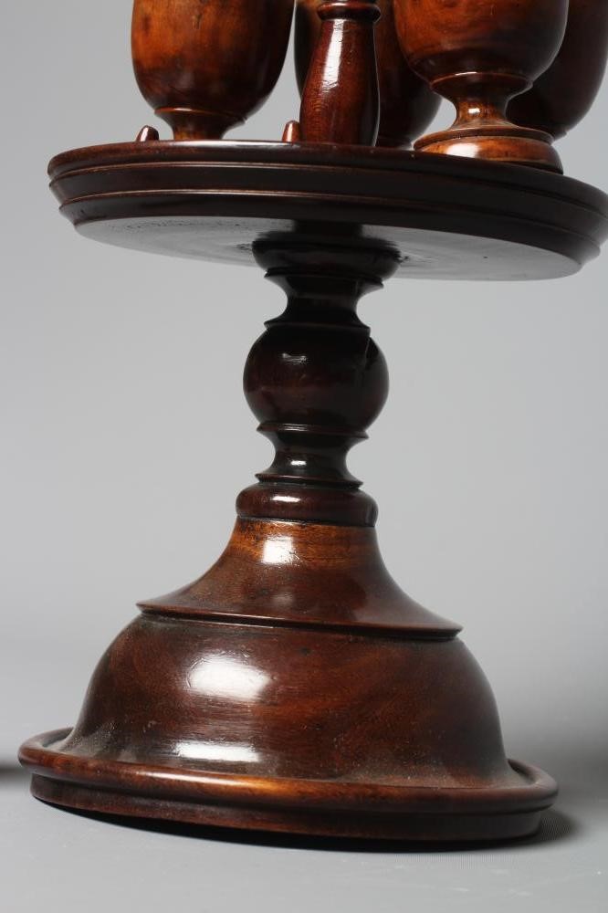 A 19th century turned mahogany egg cruet, with six cups on an upper ...