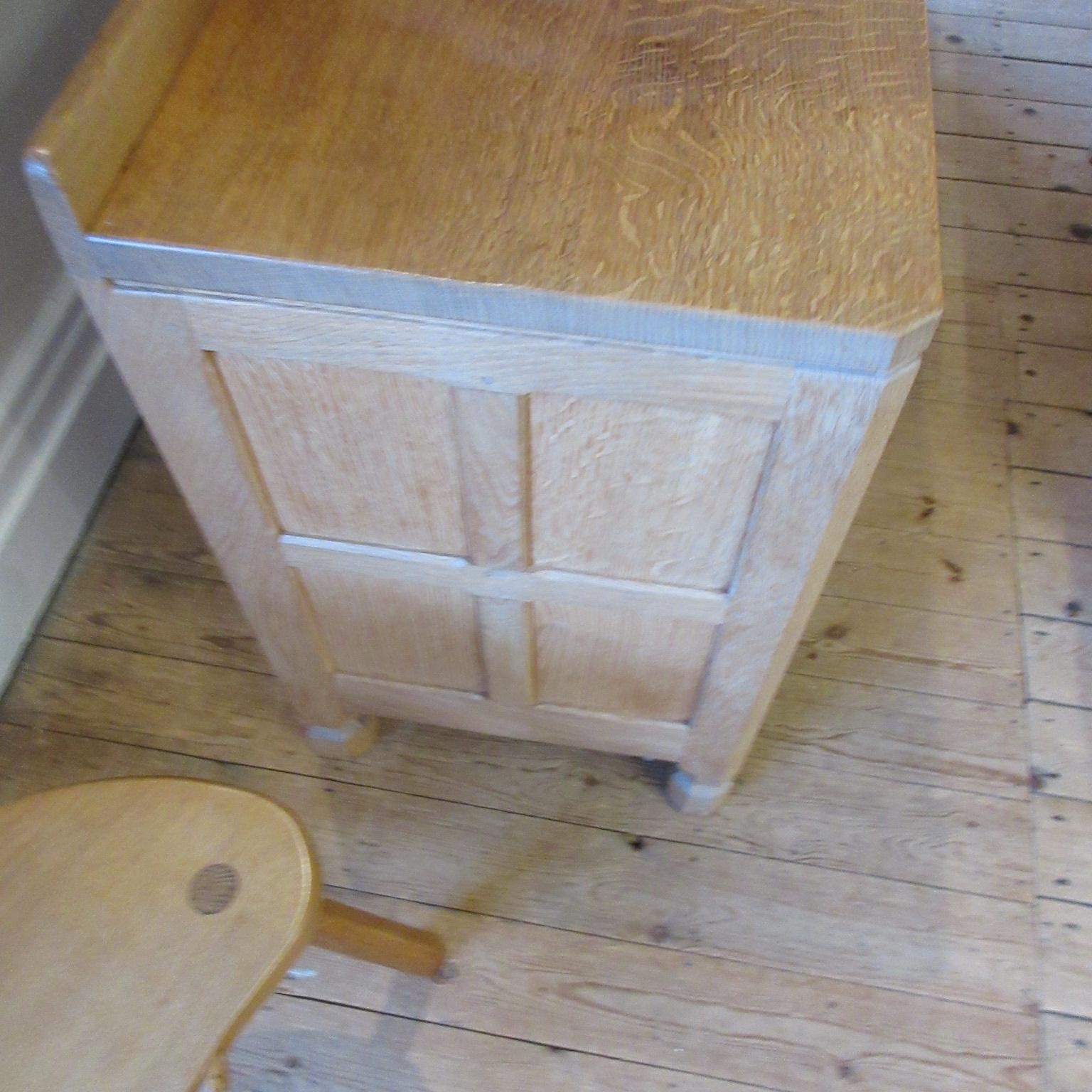 A robert thompson adzed oak sideboard of canted oblong form with ledge ...