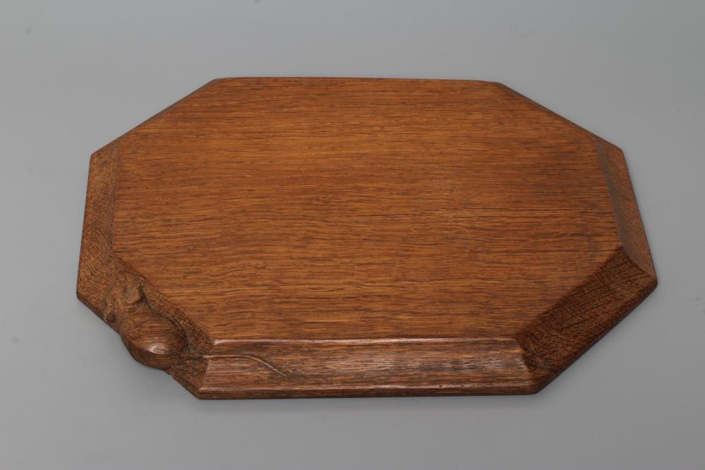 A robert thompson adzed oak bread board of canted oblong form, the ...