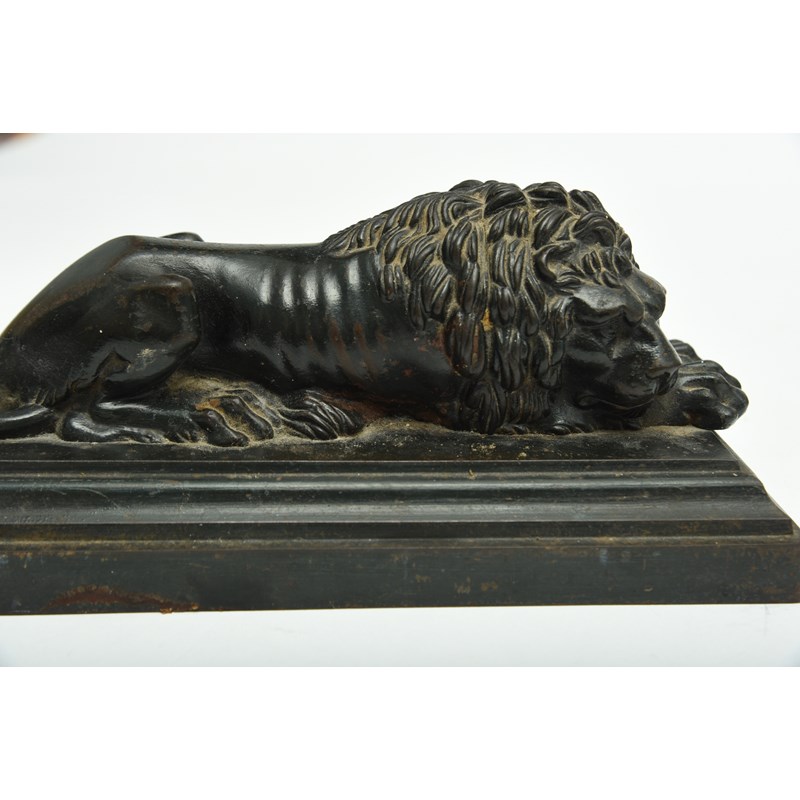 A pair of patinated cast iron models of recumbent lions | Woolley and ...