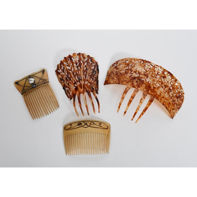 An art nouveau hair comb, set with pierced and cast white metal ...