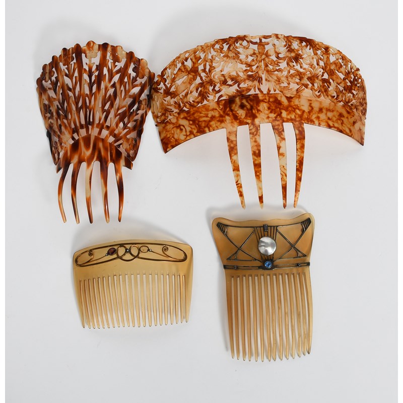 An art nouveau hair comb, set with pierced and cast white metal ...