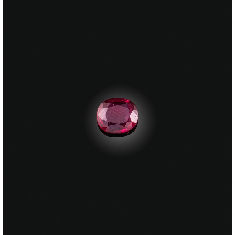 an unmounted ruby, the oval ruby weighing 1.25 carats | Woolley and Wallis