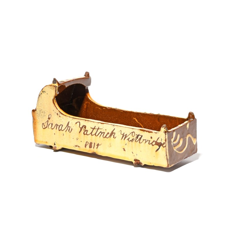 A slipware model of a cradle, dated 1815, one side incised 'sarah ...