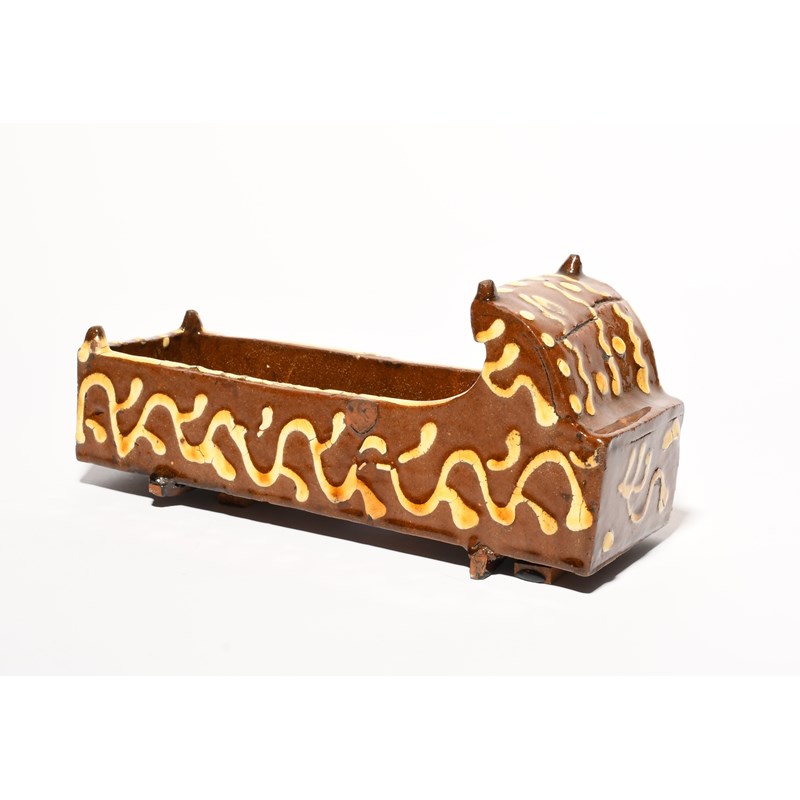 A slipware model of a cradle, dated 1815, one side incised 'sarah ...